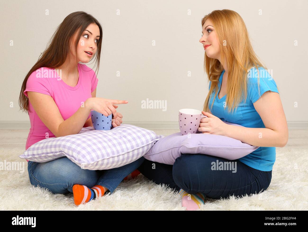 Two girl friends communicate on room Stock Photo - Alamy