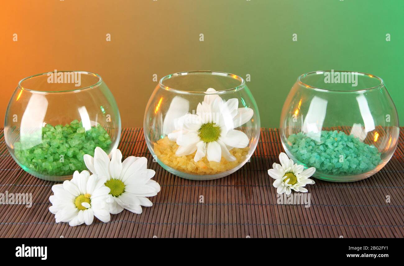 Sea salt in different colors in glass containers on bright background ...