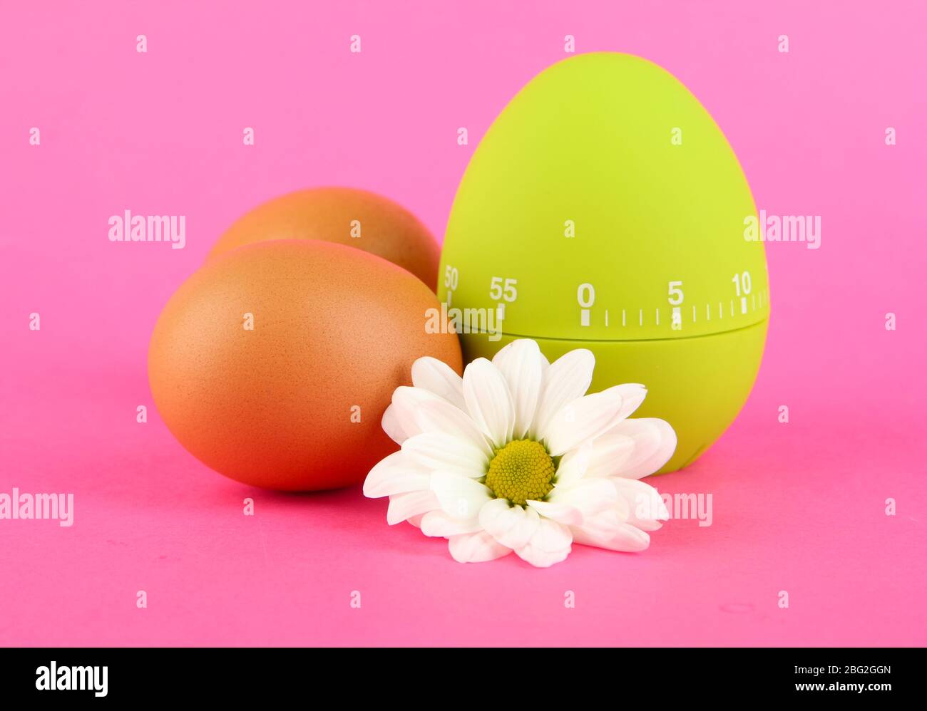 Green egg timer and eggs, on color background Stock Photo - Alamy