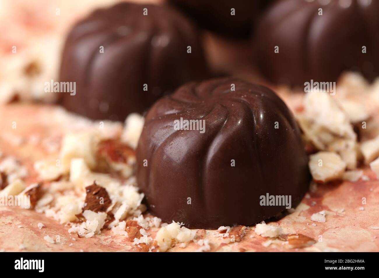 Chocolate candies with nuts, on color background Stock Photo - Alamy