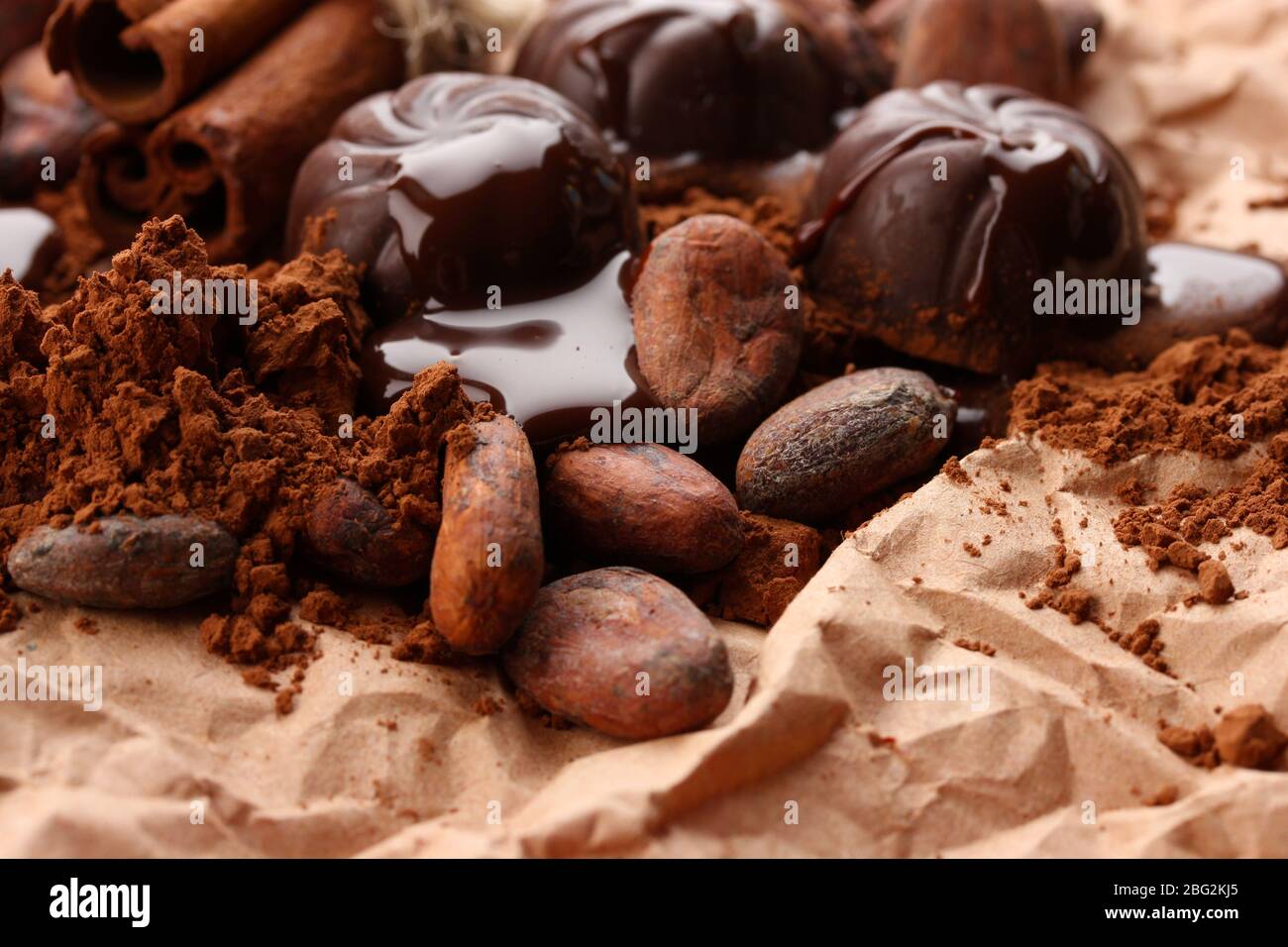 Composition of chocolate sweets, cocoa and spices on brown background ...