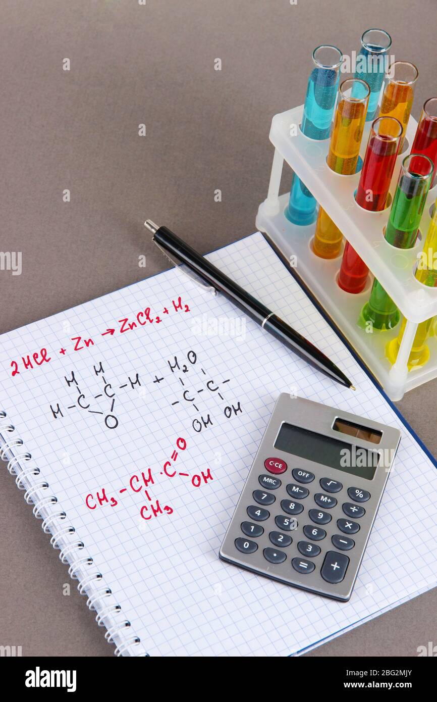 Test tubes with colorful liquids and formulas on grey background Stock ...