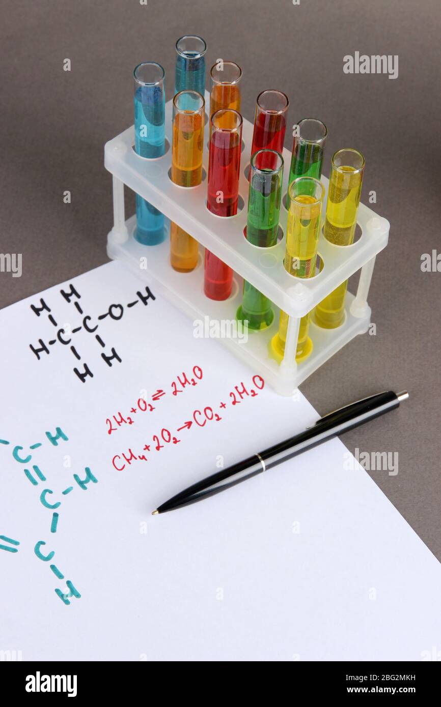 Test tubes with colorful liquids and formulas on grey background Stock ...