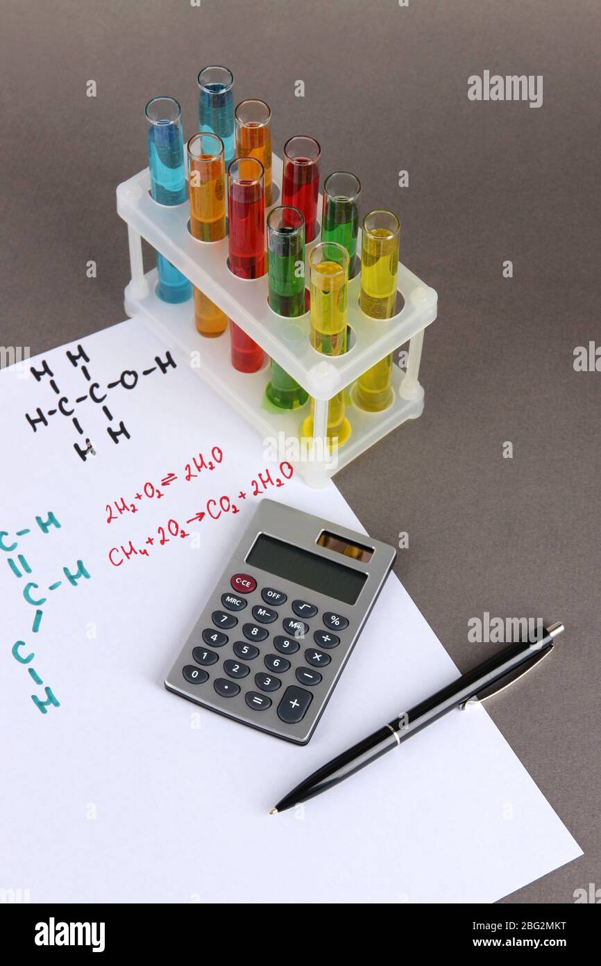 Test tubes with colorful liquids and formulas on grey background Stock ...