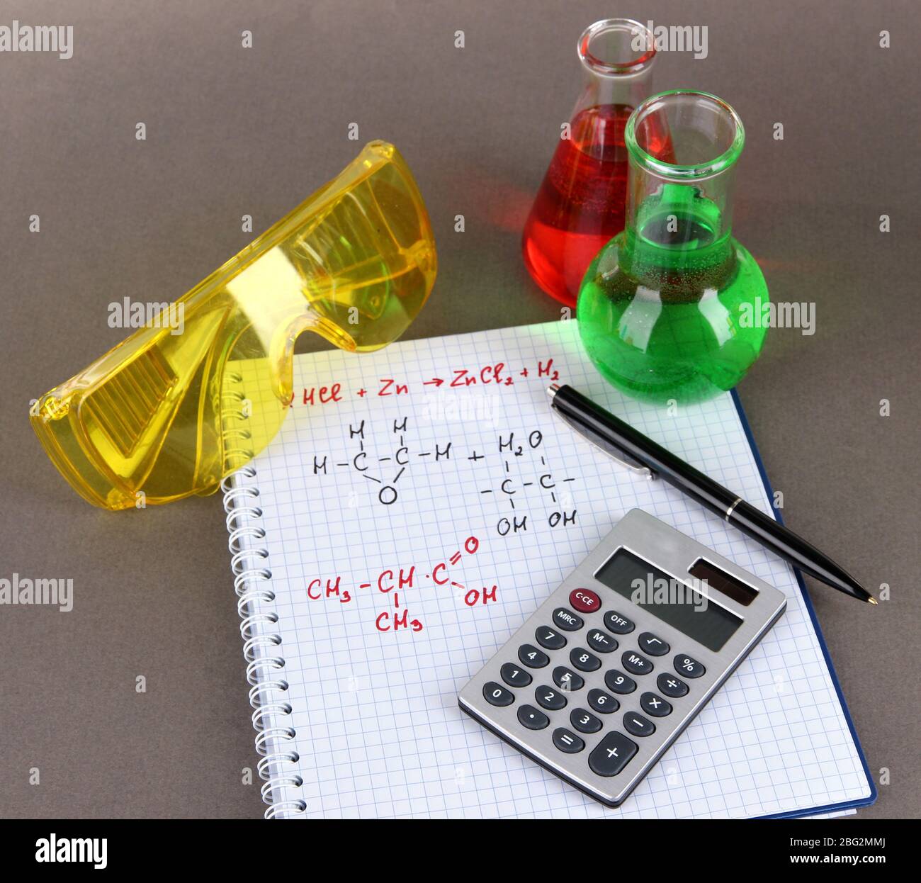 Test tubes with colorful liquids and formulas on grey background Stock ...