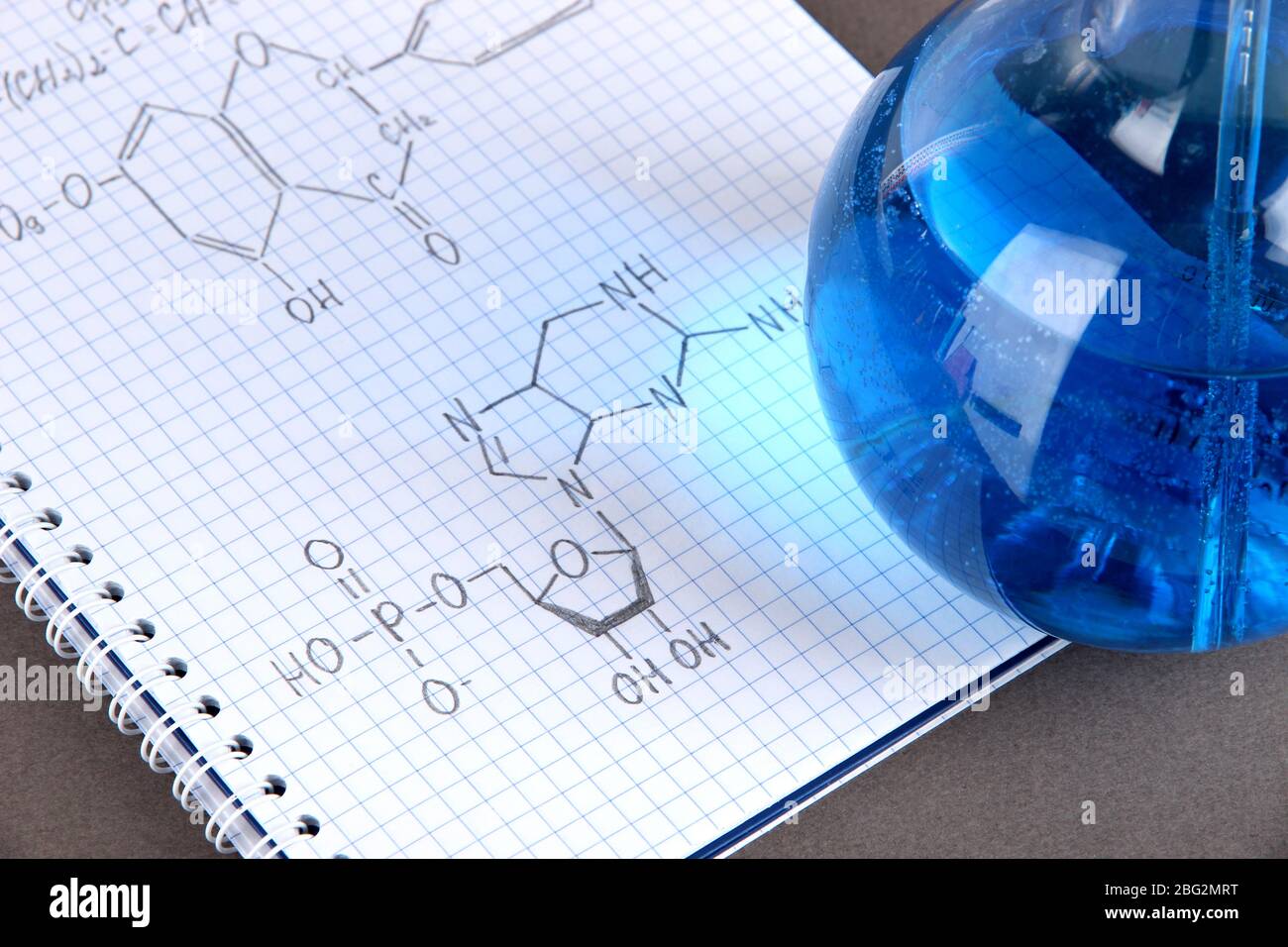 Test tube with colorful liquid and formulas on grey background Stock ...