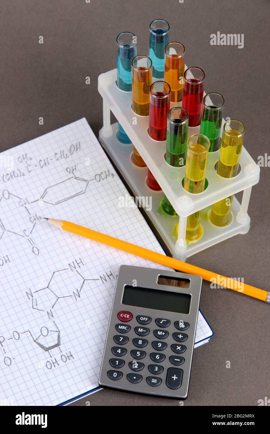Test tubes with colorful liquids and formulas on grey background Stock ...