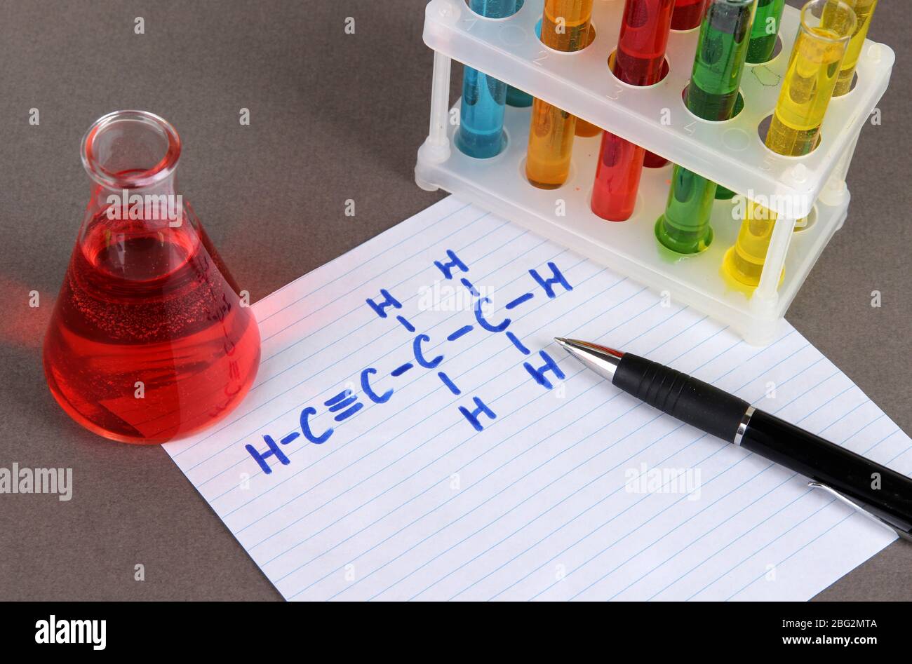 Test tubes with colorful liquids and formulas on grey background Stock ...