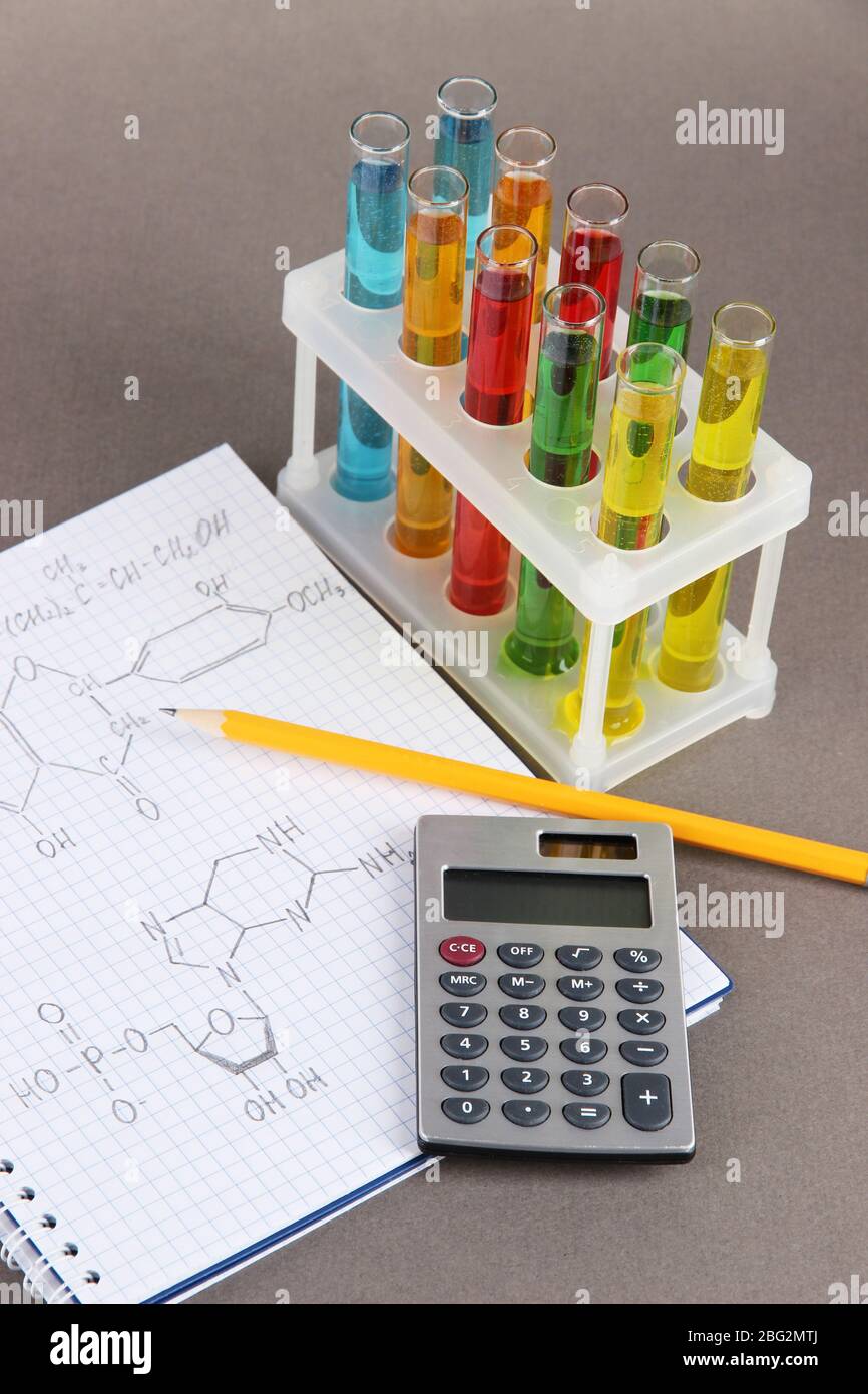 Test tubes with colorful liquids and formulas on grey background Stock ...
