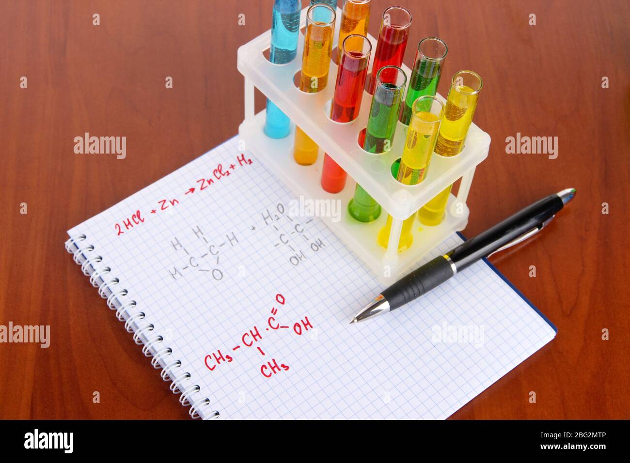 Test tubes with colorful liquids and formulas on table Stock Photo - Alamy