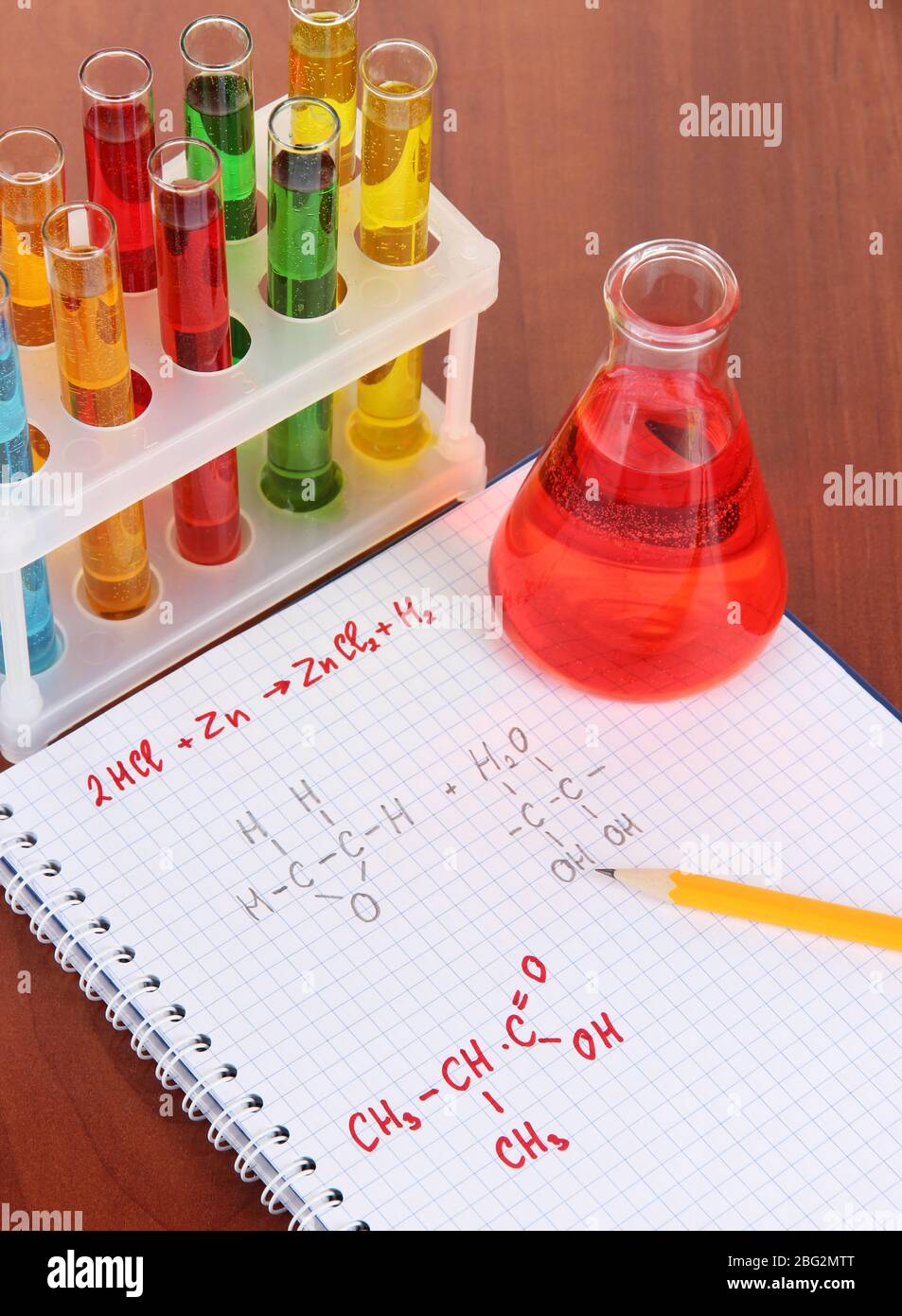 Test tubes with colorful liquids and formulas on table Stock Photo - Alamy