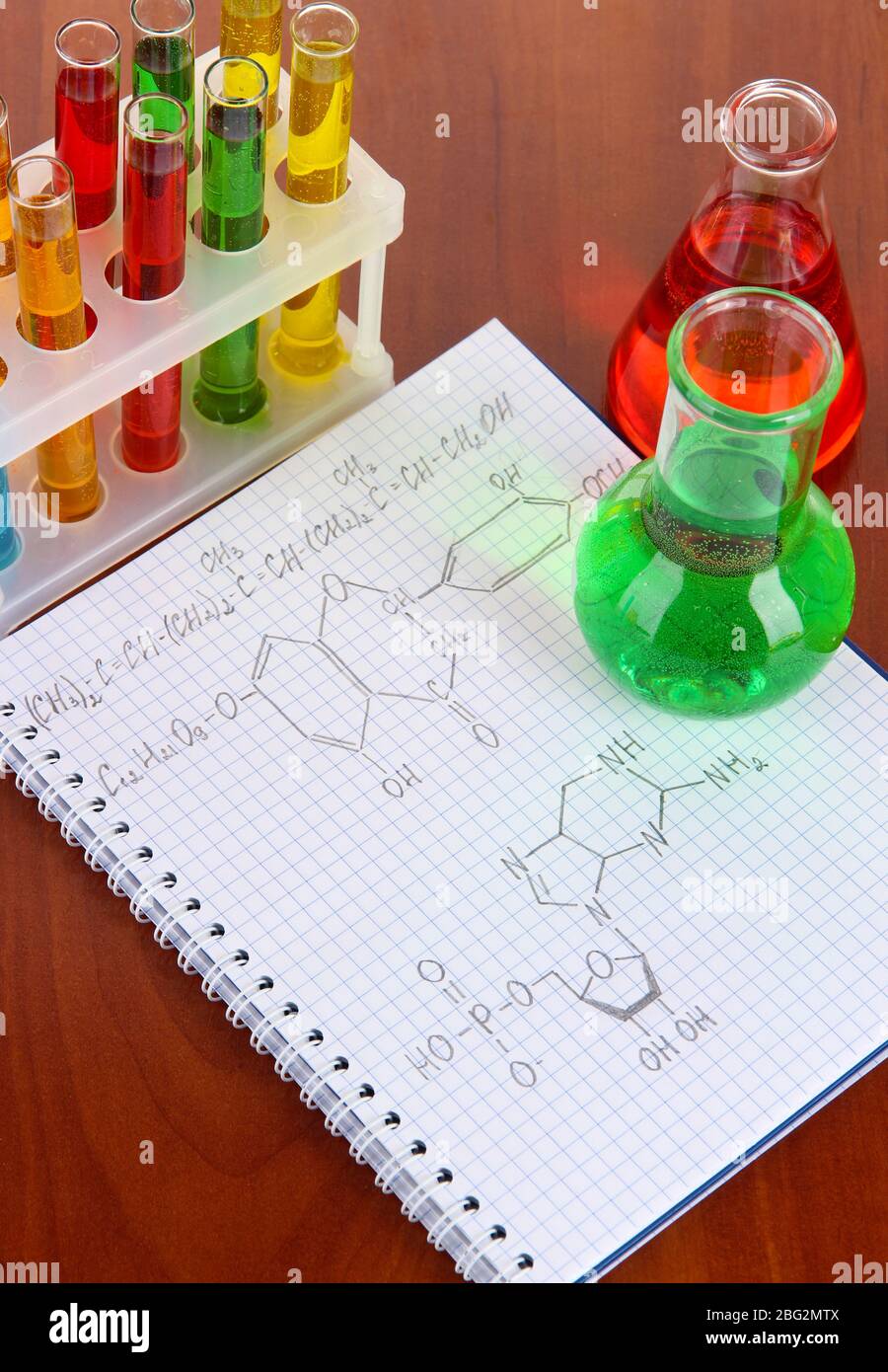 Test tubes with colorful liquids and formulas on table Stock Photo - Alamy