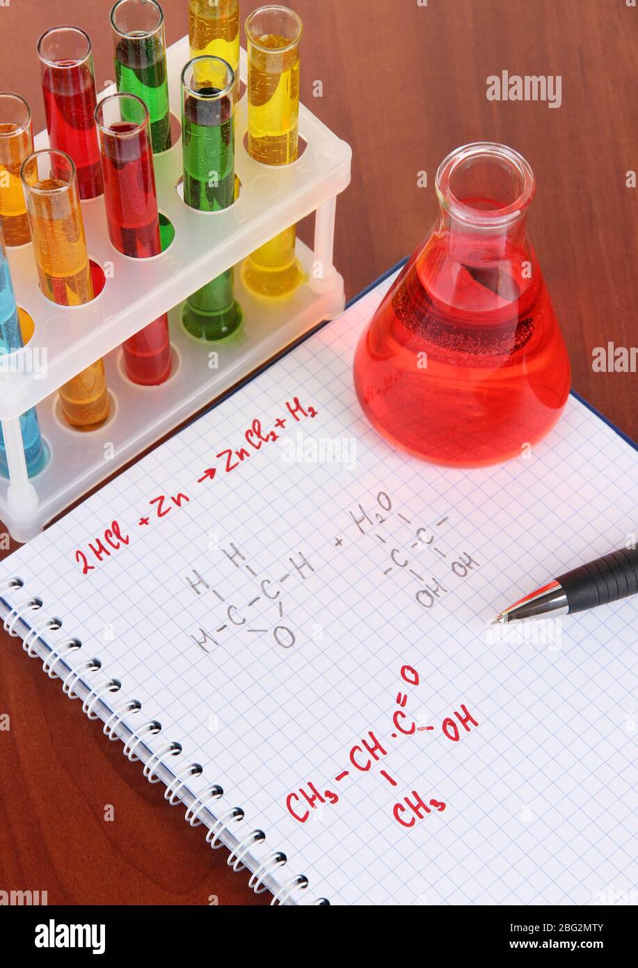 Test tubes with colorful liquids and formulas on table Stock Photo - Alamy