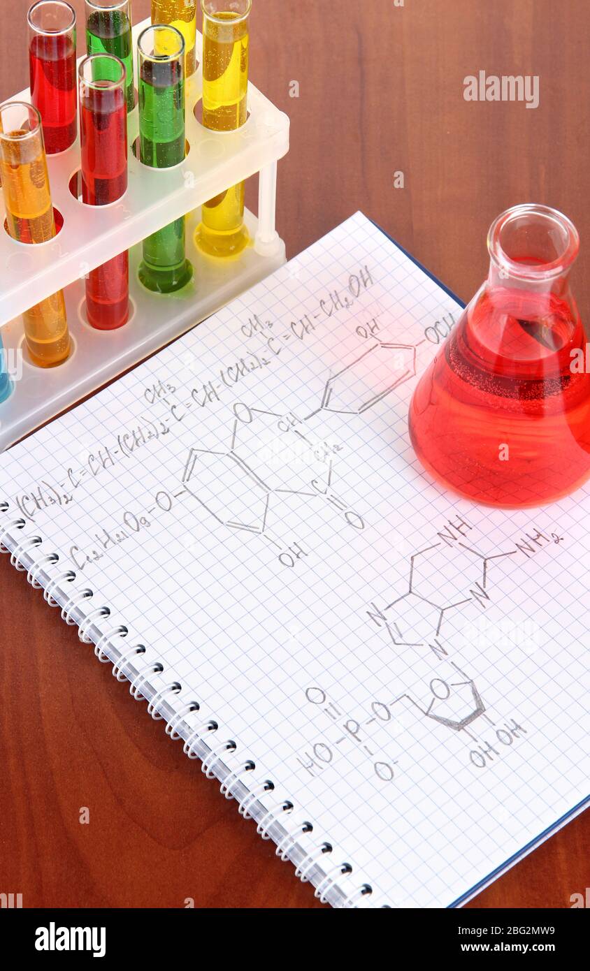 Test tubes with colorful liquids and formulas on table Stock Photo - Alamy
