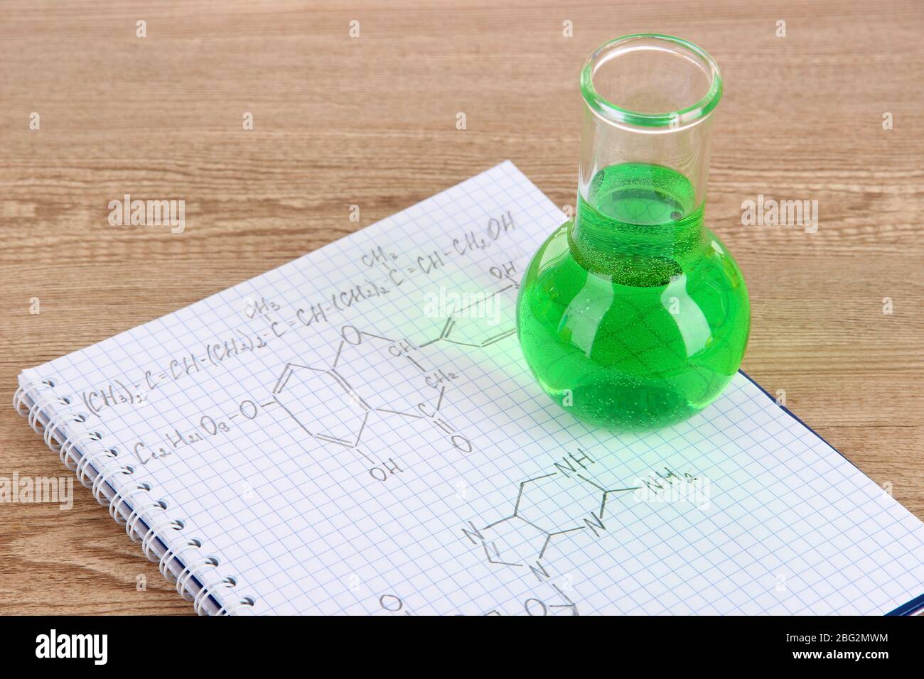 Test tube with colorful liquid and formulas on table Stock Photo - Alamy