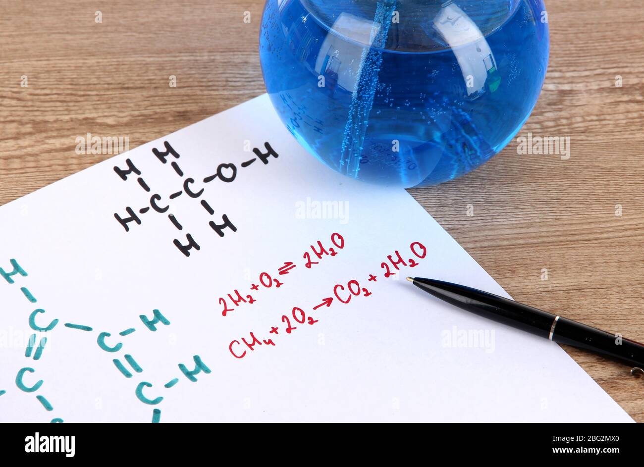 Test tube with colorful liquid and formulas on table Stock Photo - Alamy