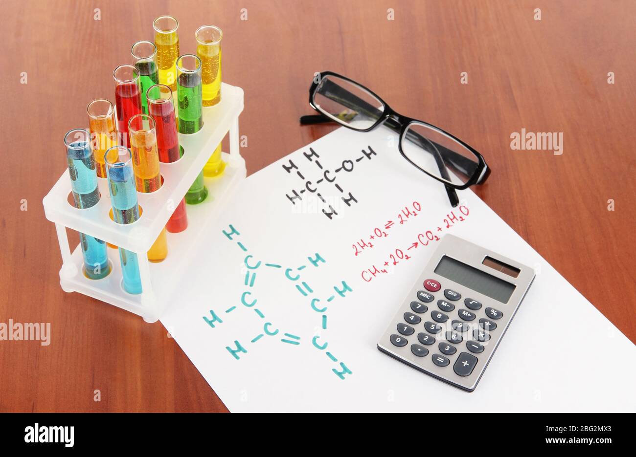 Test tubes with colorful liquids and formulas on table Stock Photo - Alamy