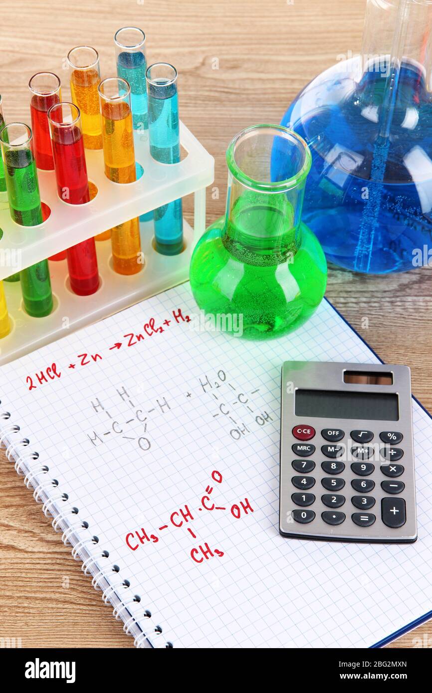 Test tubes with colorful liquids and formulas on table Stock Photo - Alamy