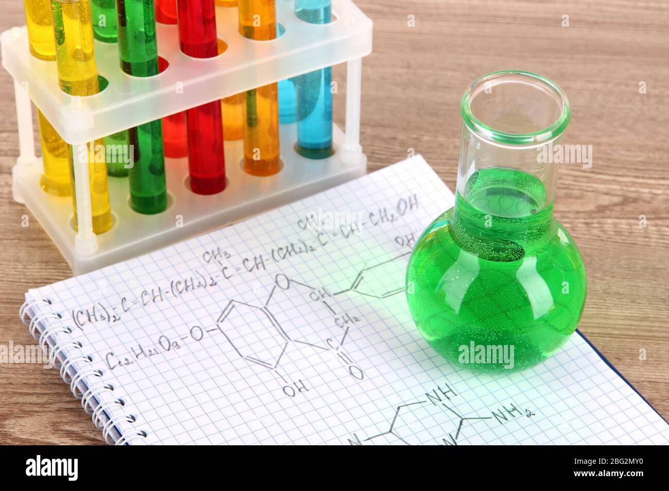 Test tubes with colorful liquids and formulas on table Stock Photo - Alamy