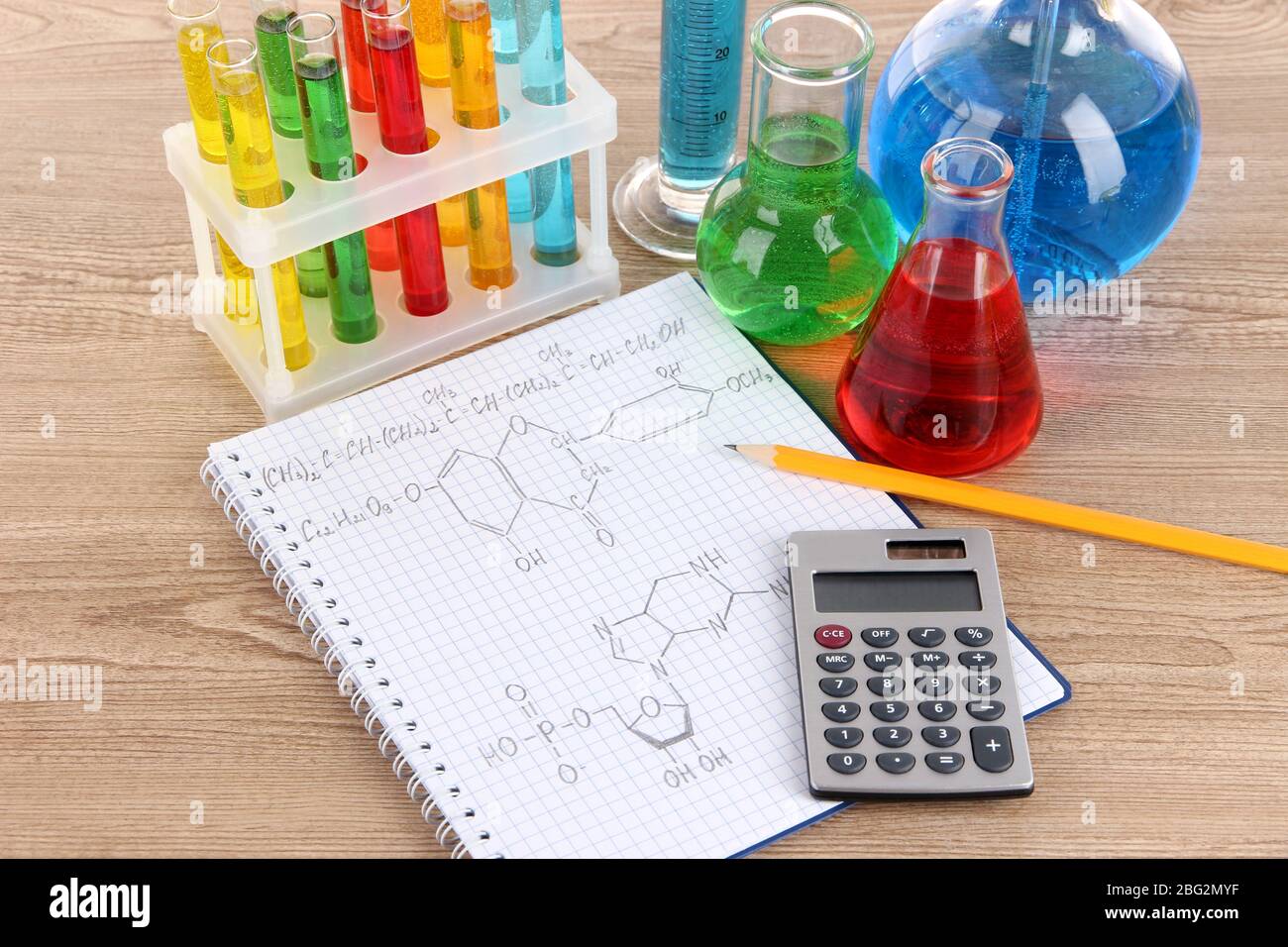 Test tubes with colorful liquids and formulas on table Stock Photo - Alamy