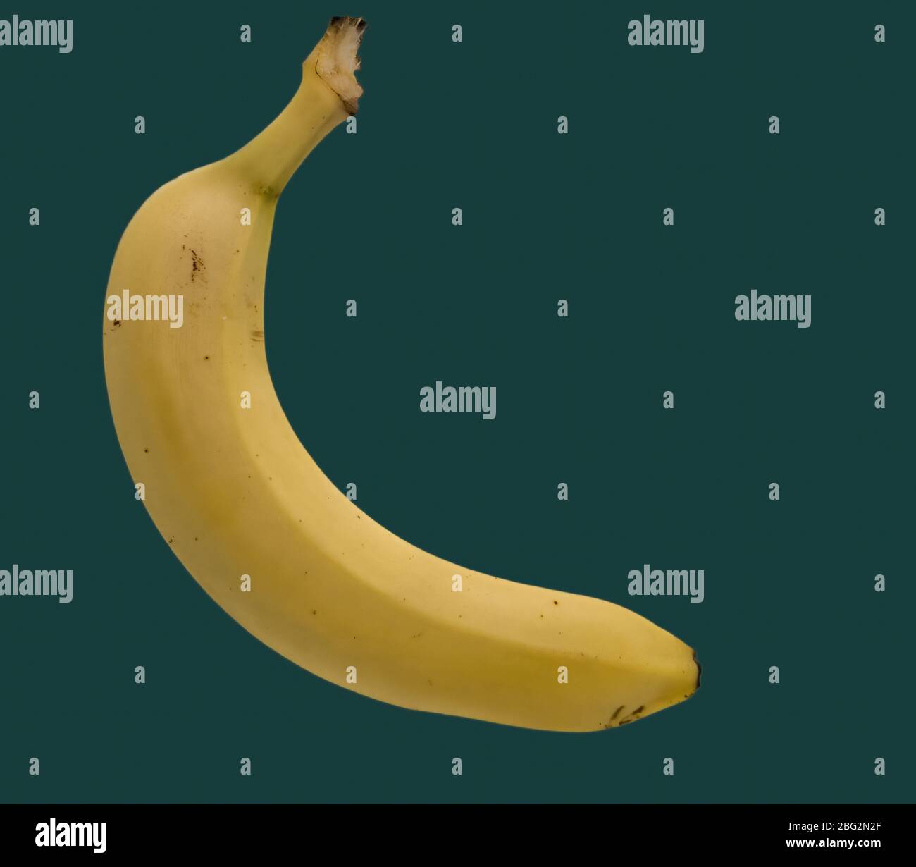 Single yellow banana isolated on green background Stock Photo - Alamy