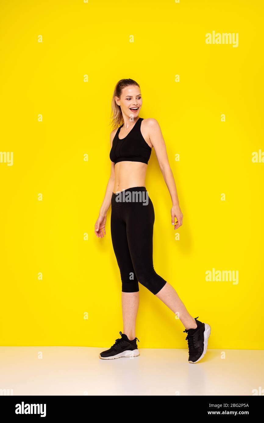 side veiw of a athletic woman in sportwear on yellow background Stock ...