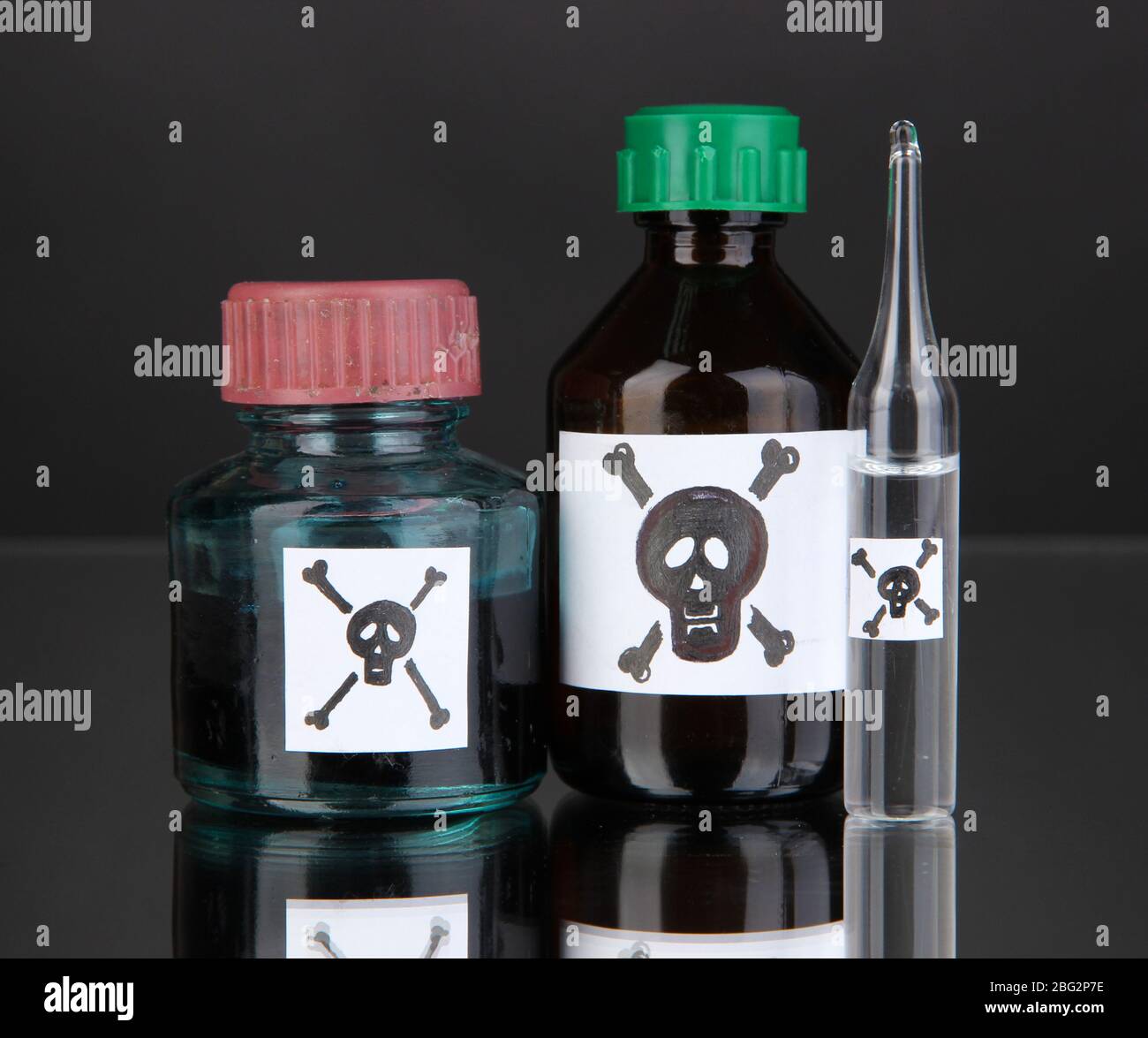 Deadly poison in bottles on black background Stock Photo - Alamy