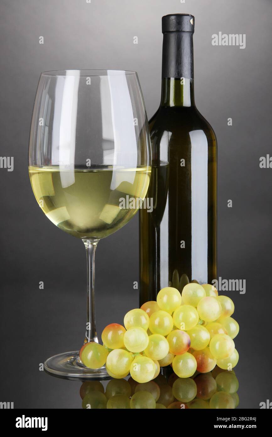 White wine glass and bottle of wine on grey background Stock Photo - Alamy