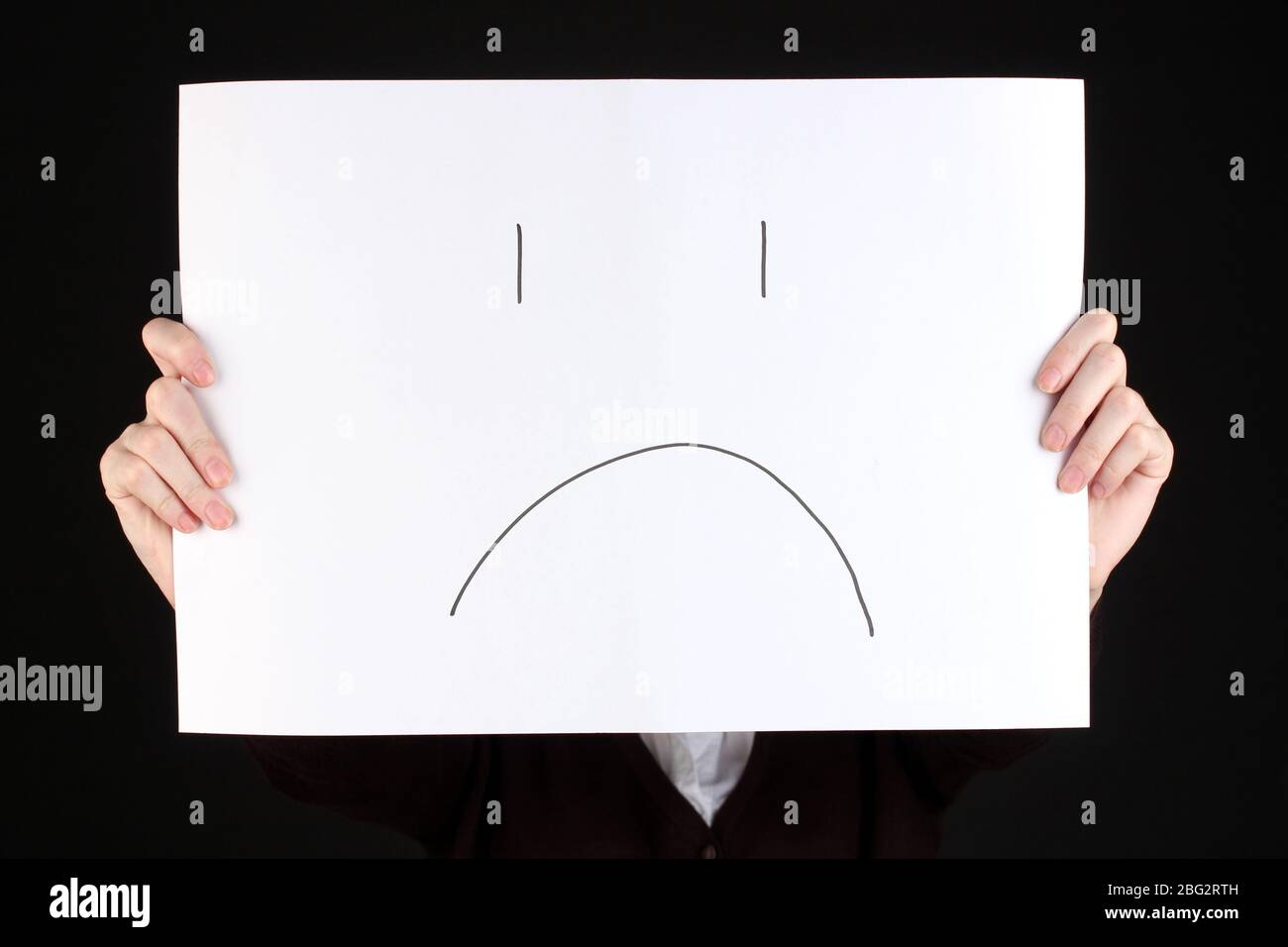 Woman holding paper with sad emoticon, isolated on black Stock Photo ...