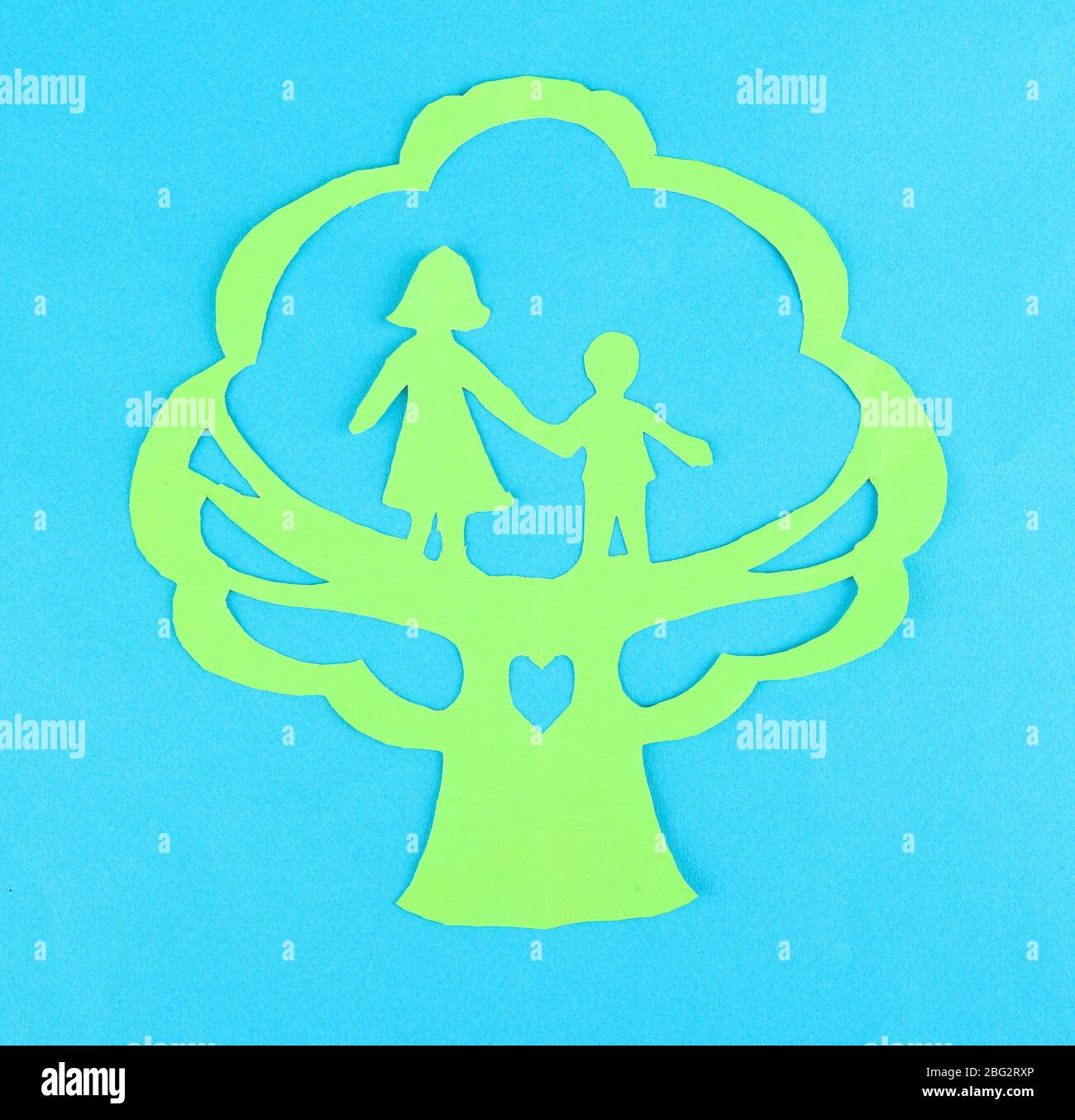 Green cut out paper tree with people inside, on color background Stock ...
