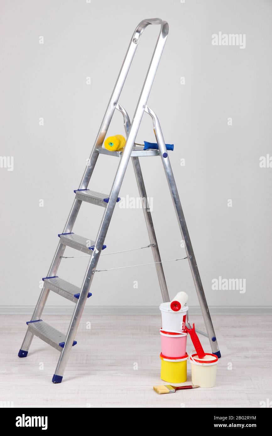 Metal ladder and paint in room Stock Photo - Alamy