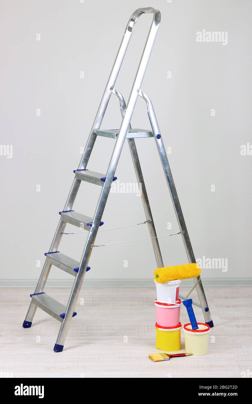 Metal ladder and paint in room Stock Photo - Alamy