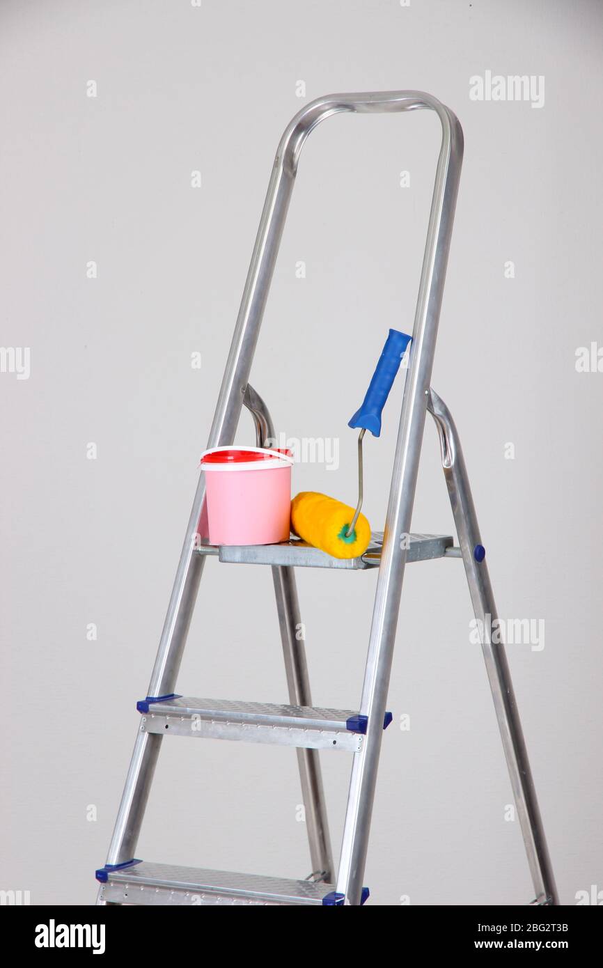 Metal ladder and paint in room Stock Photo - Alamy