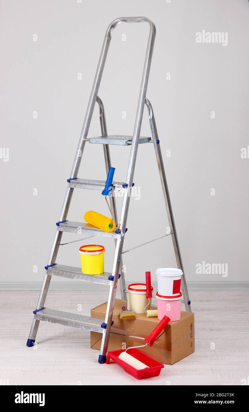 Metal ladder and paint in room Stock Photo - Alamy