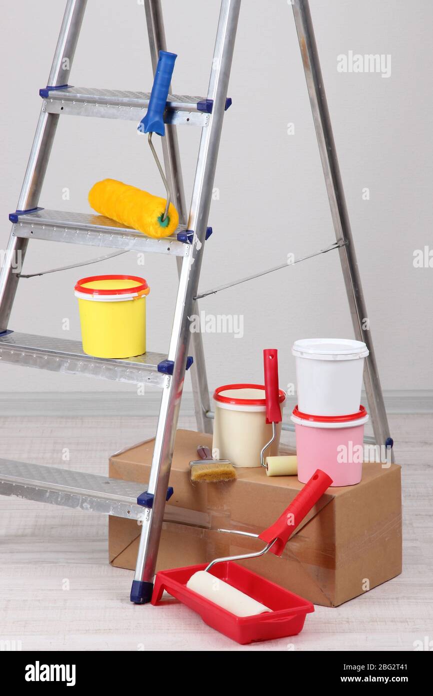 Metal ladder and paint in room Stock Photo - Alamy