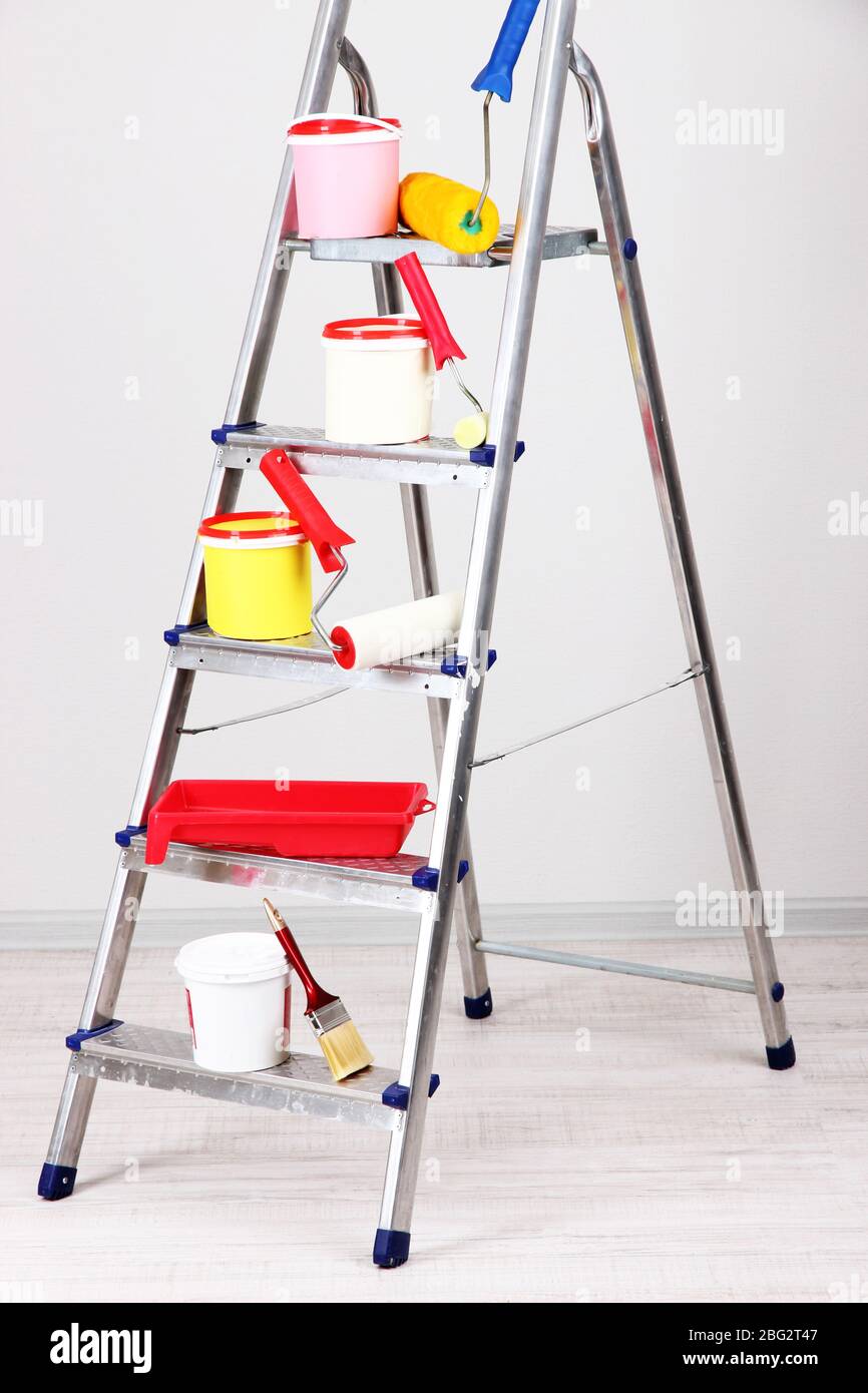 Metal ladder and paint in room Stock Photo - Alamy