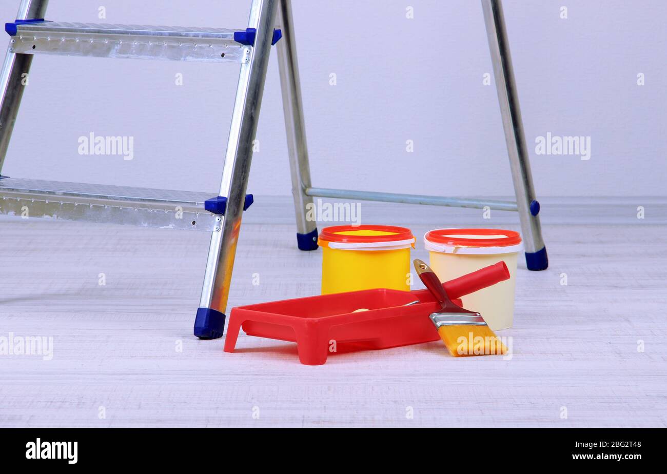 Metal ladder and paint in room Stock Photo - Alamy