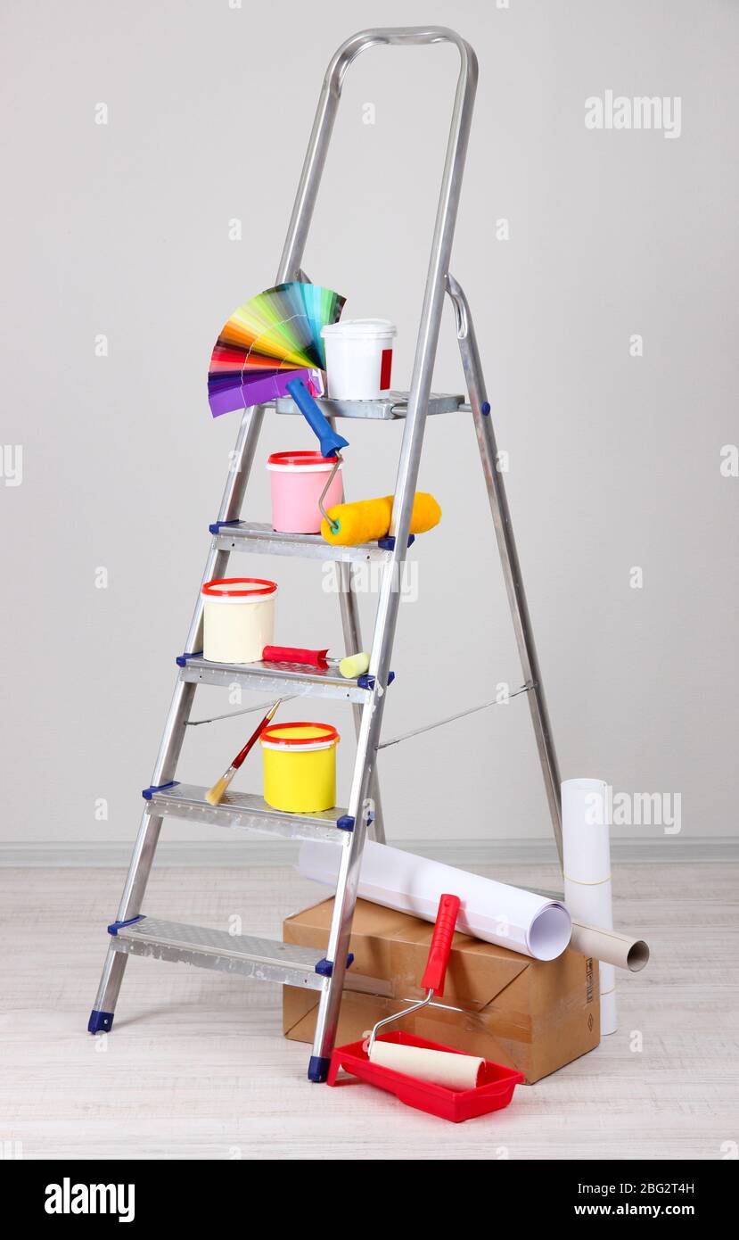 Metal ladder and paint in room Stock Photo - Alamy