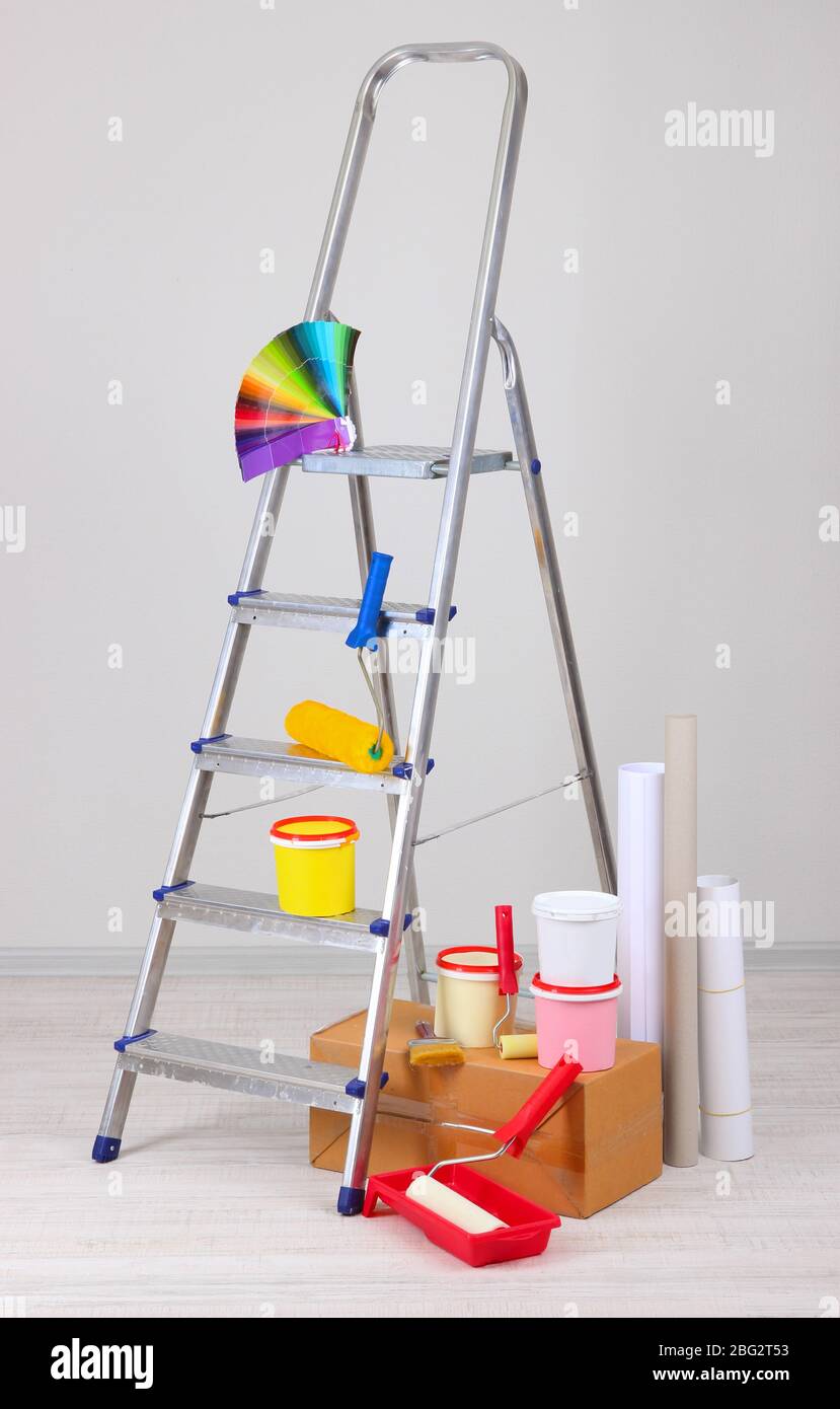 Metal ladder and paint in room Stock Photo - Alamy