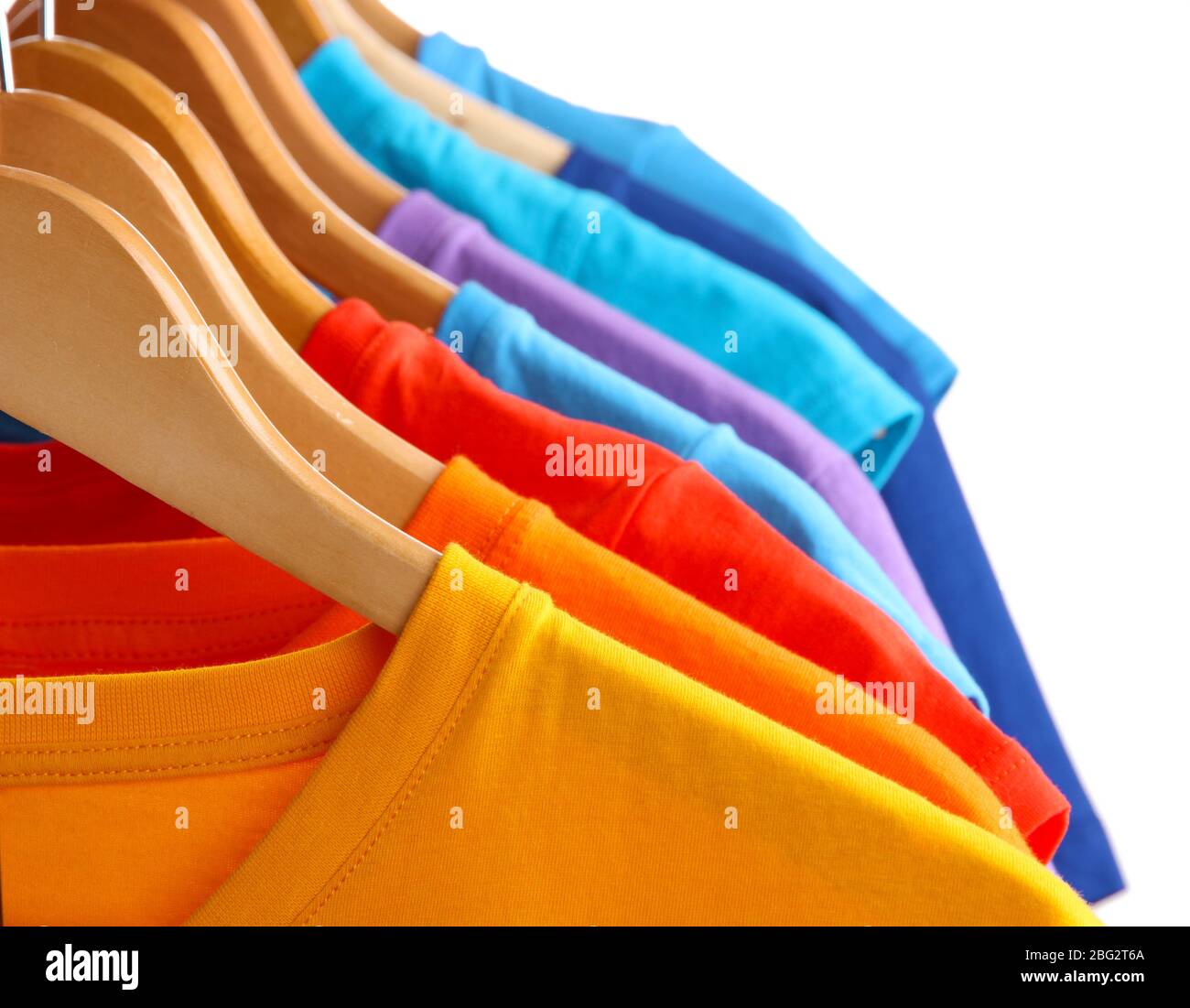 Lots of T-shirts on hangers isolated on white Stock Photo - Alamy