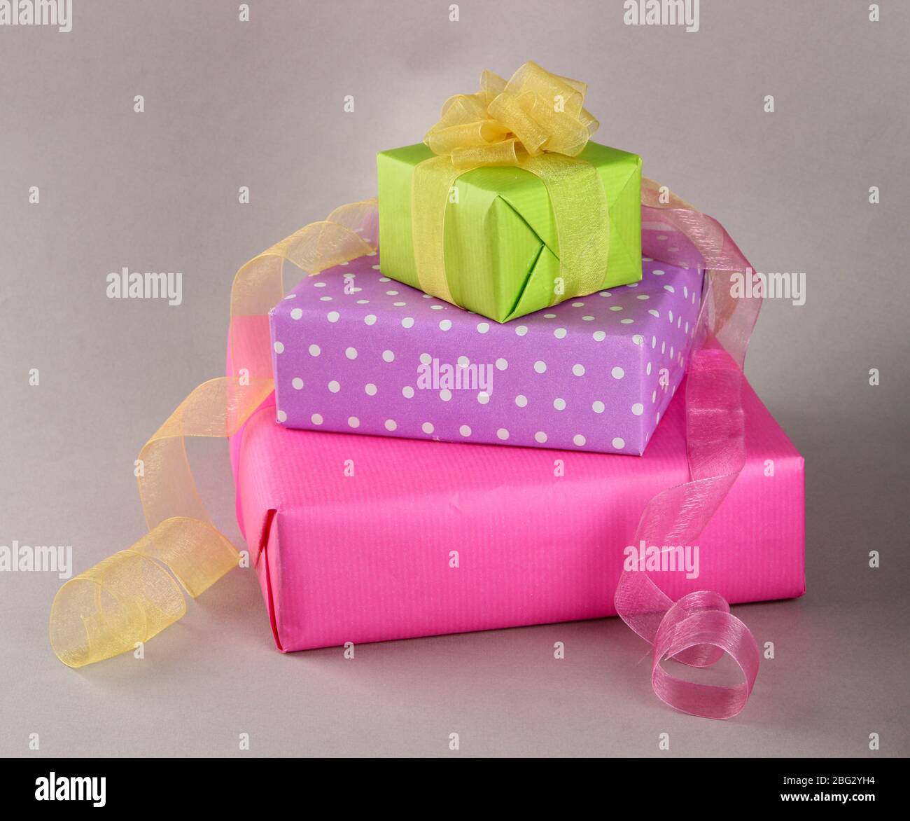 Bright gifts with bows on grey background Stock Photo - Alamy