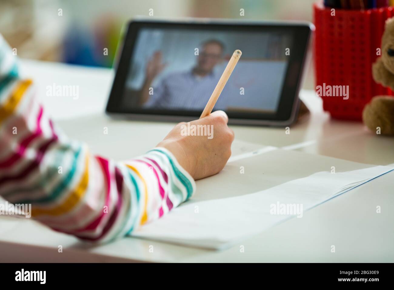 Primary school student having video conference call with teacher using ...