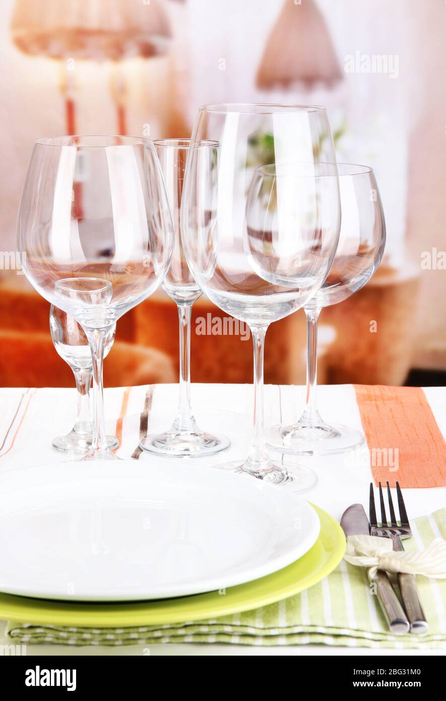 Table setting with glasses for different drinks on table on room ...