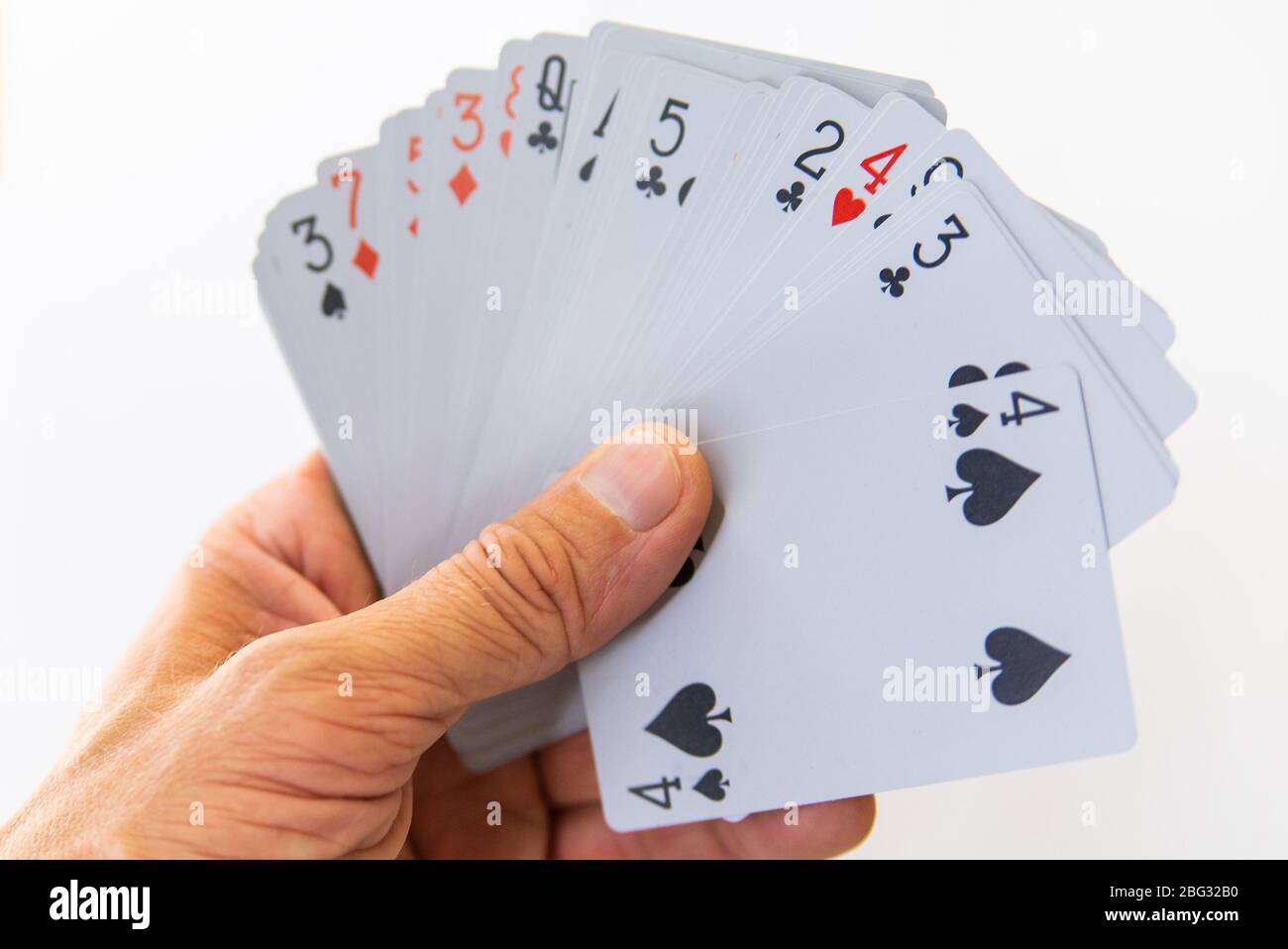 Playing cards in hand isolated on white background Stock Photo - Alamy