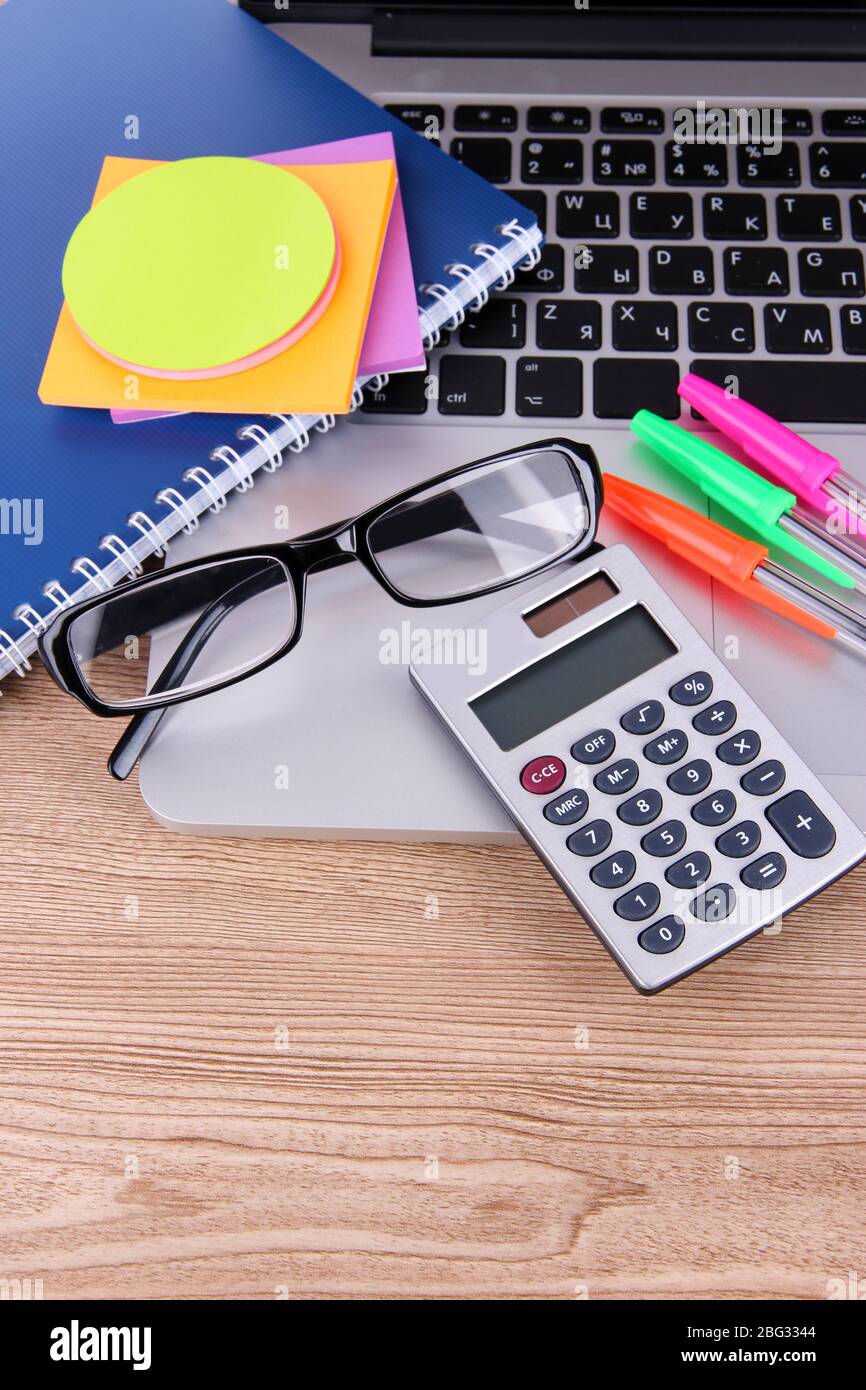 Laptop with stationery on table Stock Photo - Alamy