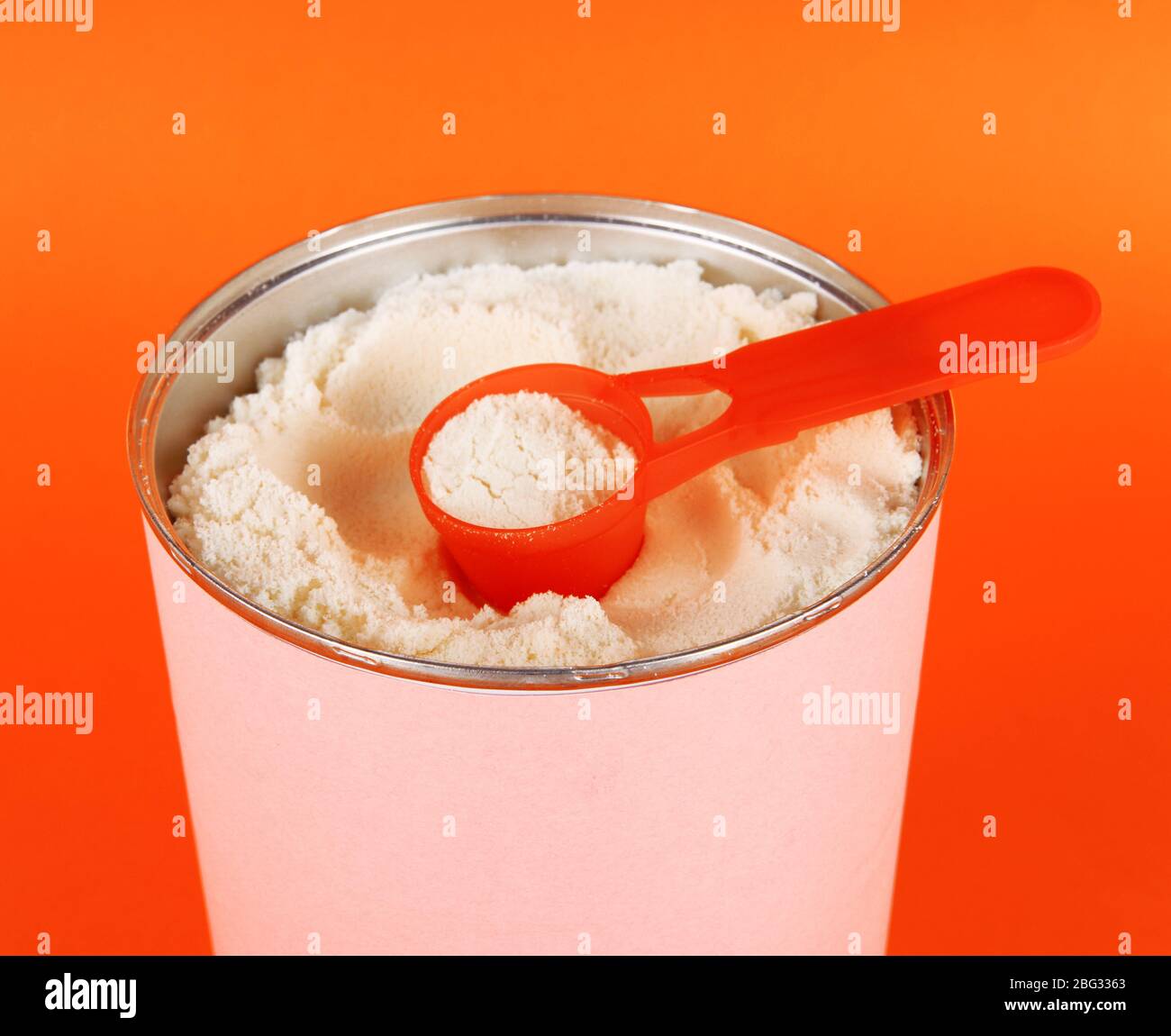 Powdered milk for baby on orange background Stock Photo - Alamy