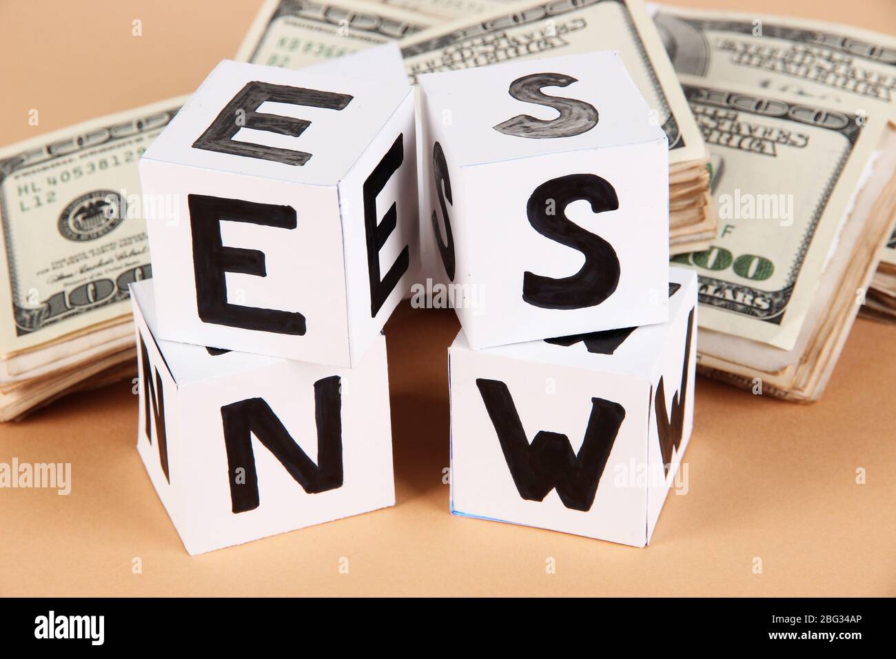 White paper cubes labeled "News" with money on beige background Stock ...