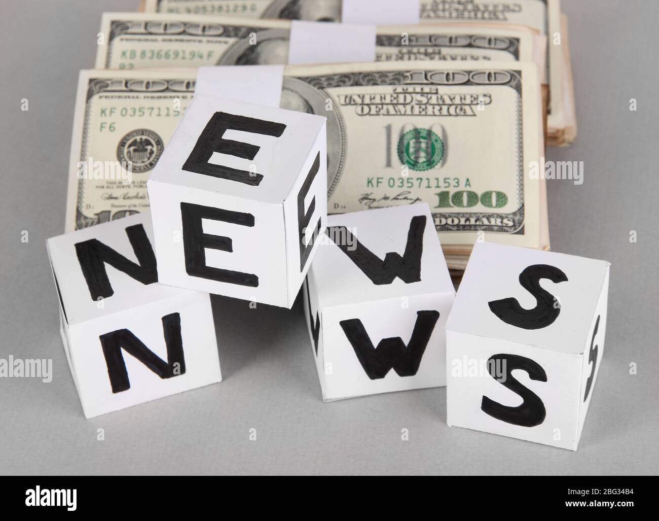 White paper cubes labeled "News" with money on grey background Stock ...