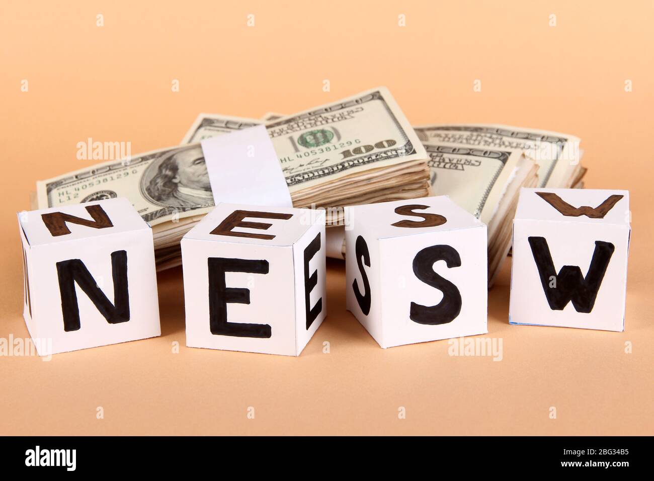 White paper cubes labeled "News" with money on beige background Stock ...
