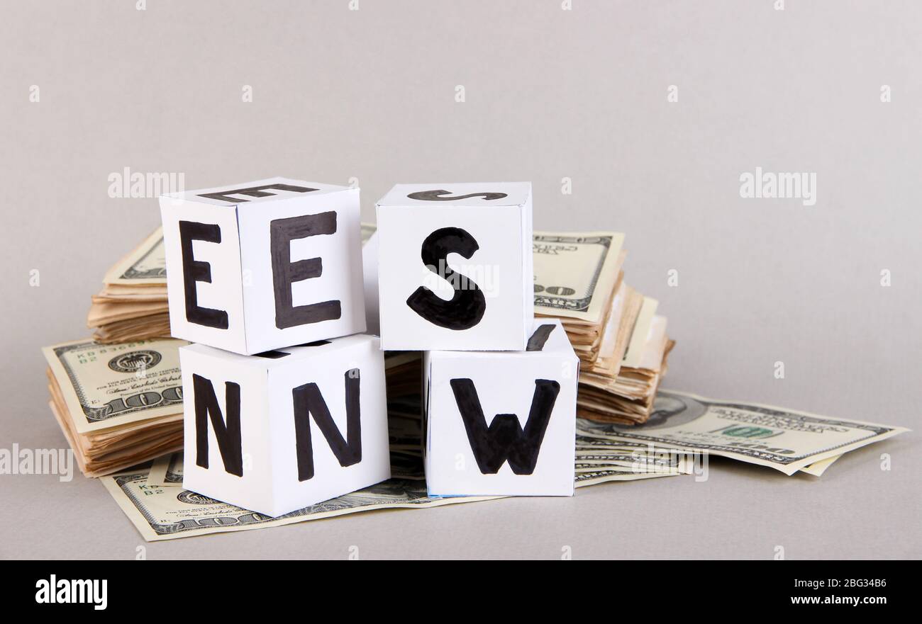 White paper cubes labeled News with money on grey background Stock ...
